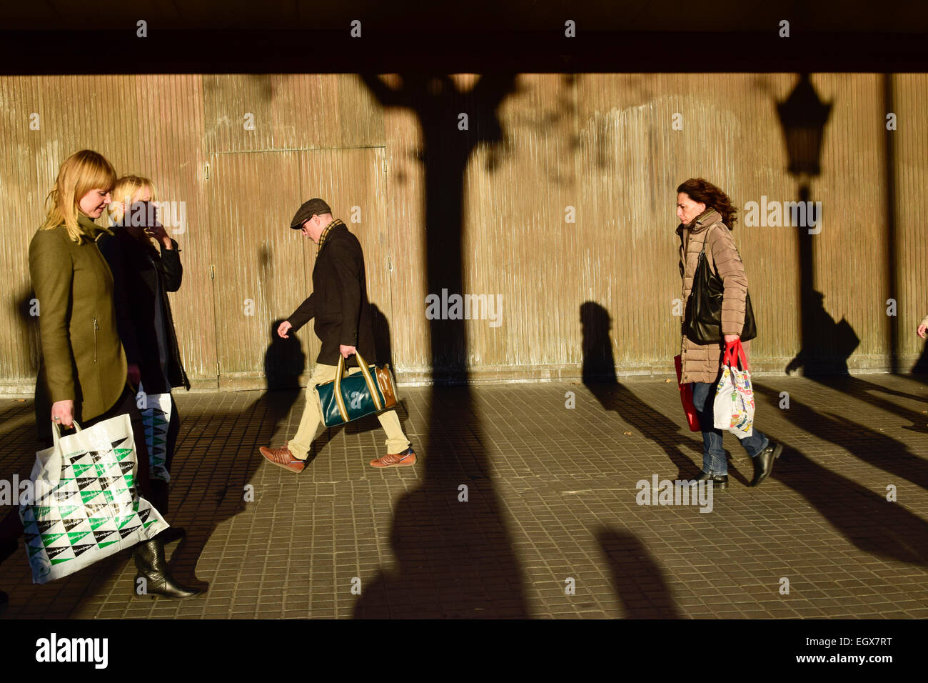 People walking along a wall Stock Photo - Alamy