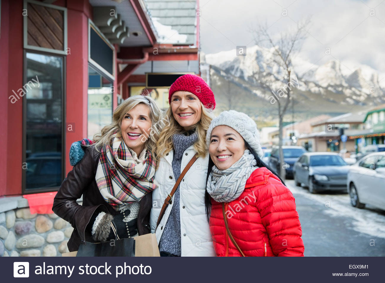 Smiling women in warm clothing outside storefront Stock Photo - Alamy