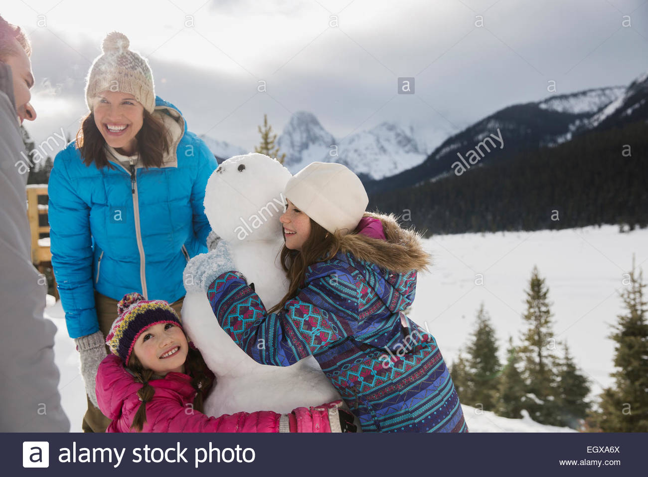 Girls hugging snowman below mountains Stock Photo - Alamy Girls hugging snowman below mountains Stock Photo - Alamy