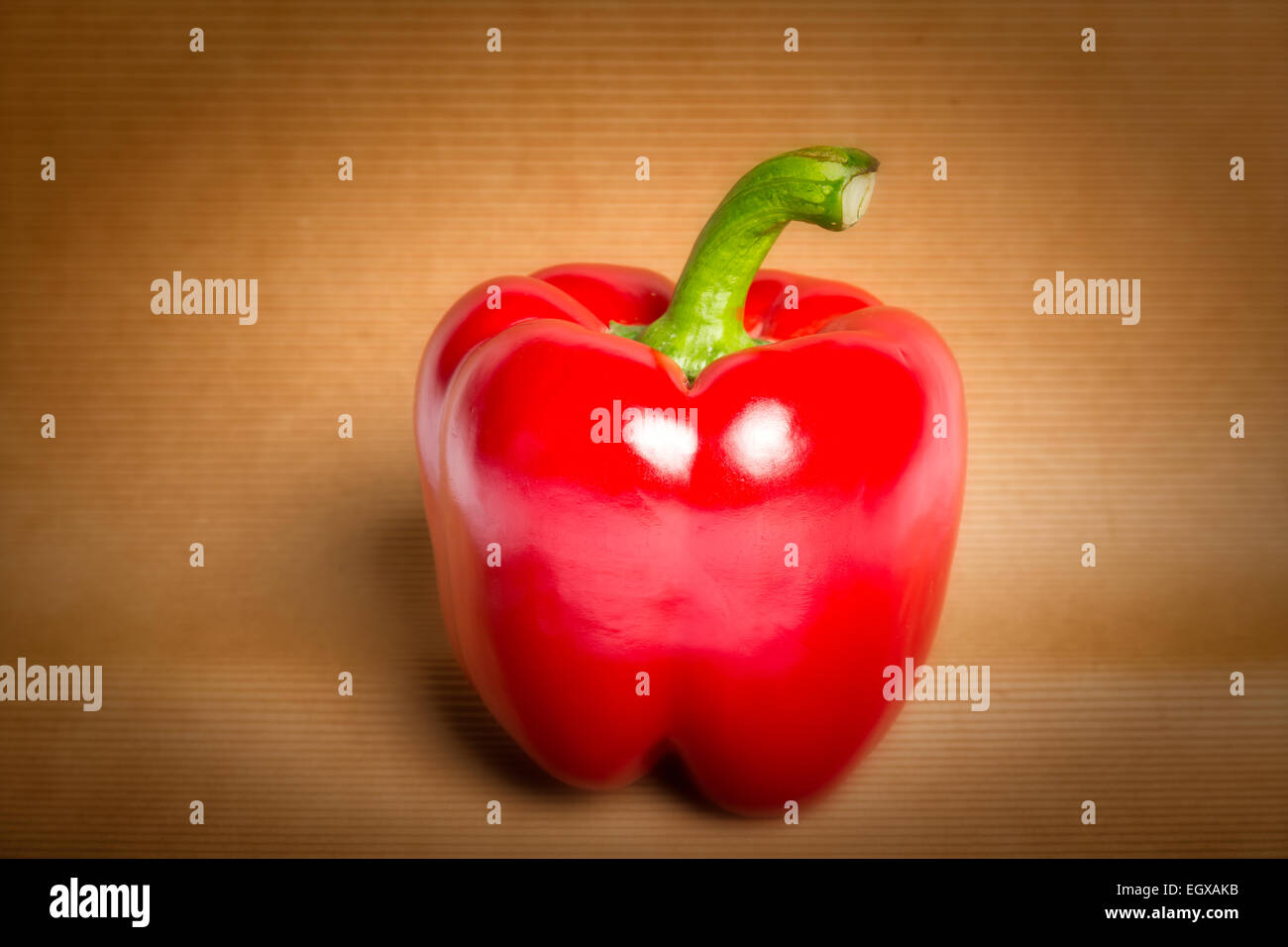 A single red pepper on paper background Stock Photo - Alamy