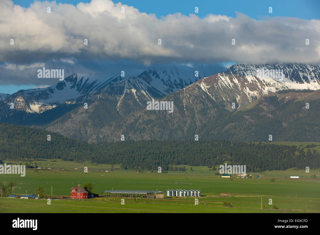A red round barn below the Wallowa Mountain range in eastern Oregon ...