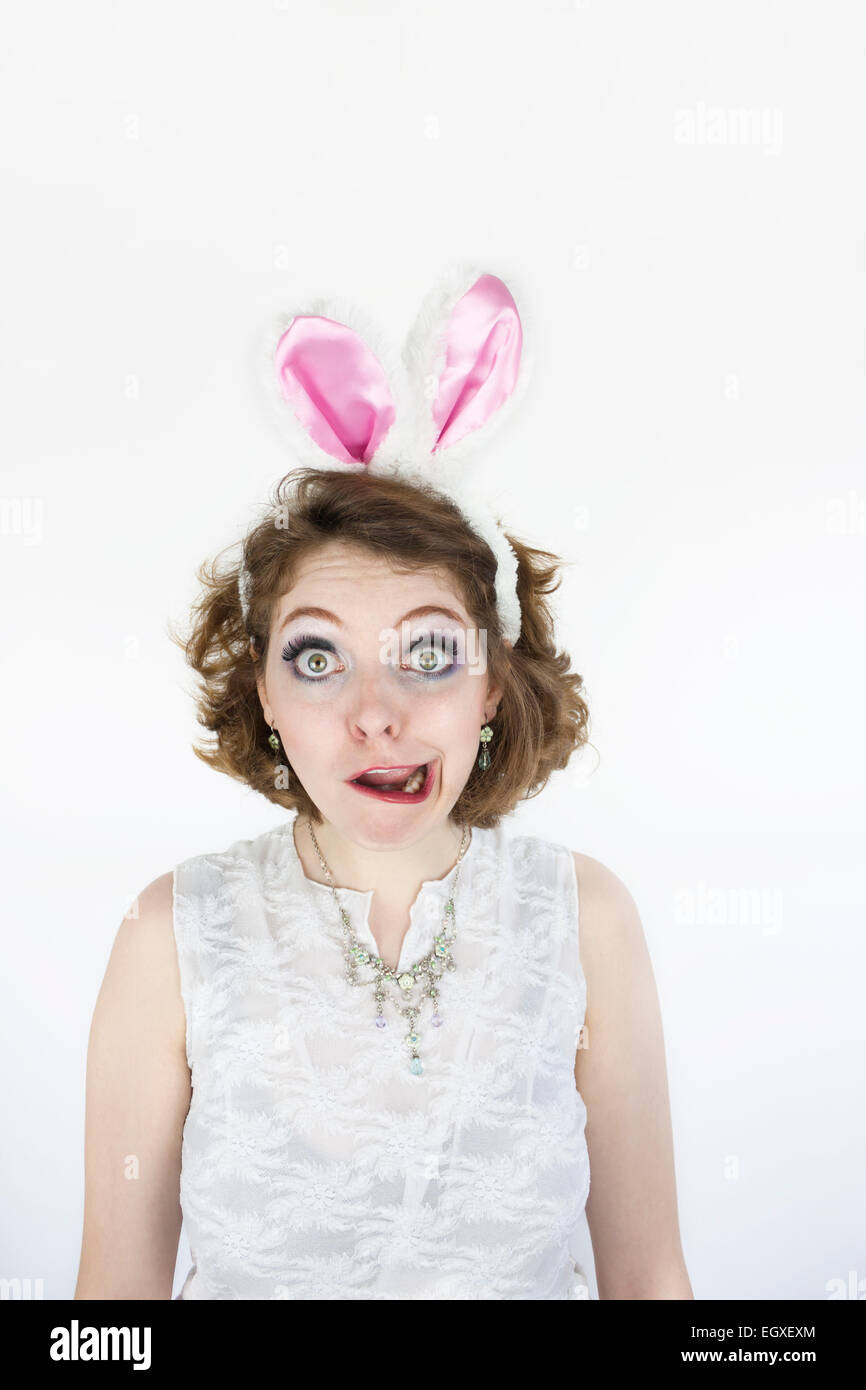 Beautiful young woman wearing Easter rabbit ears making funny face ...