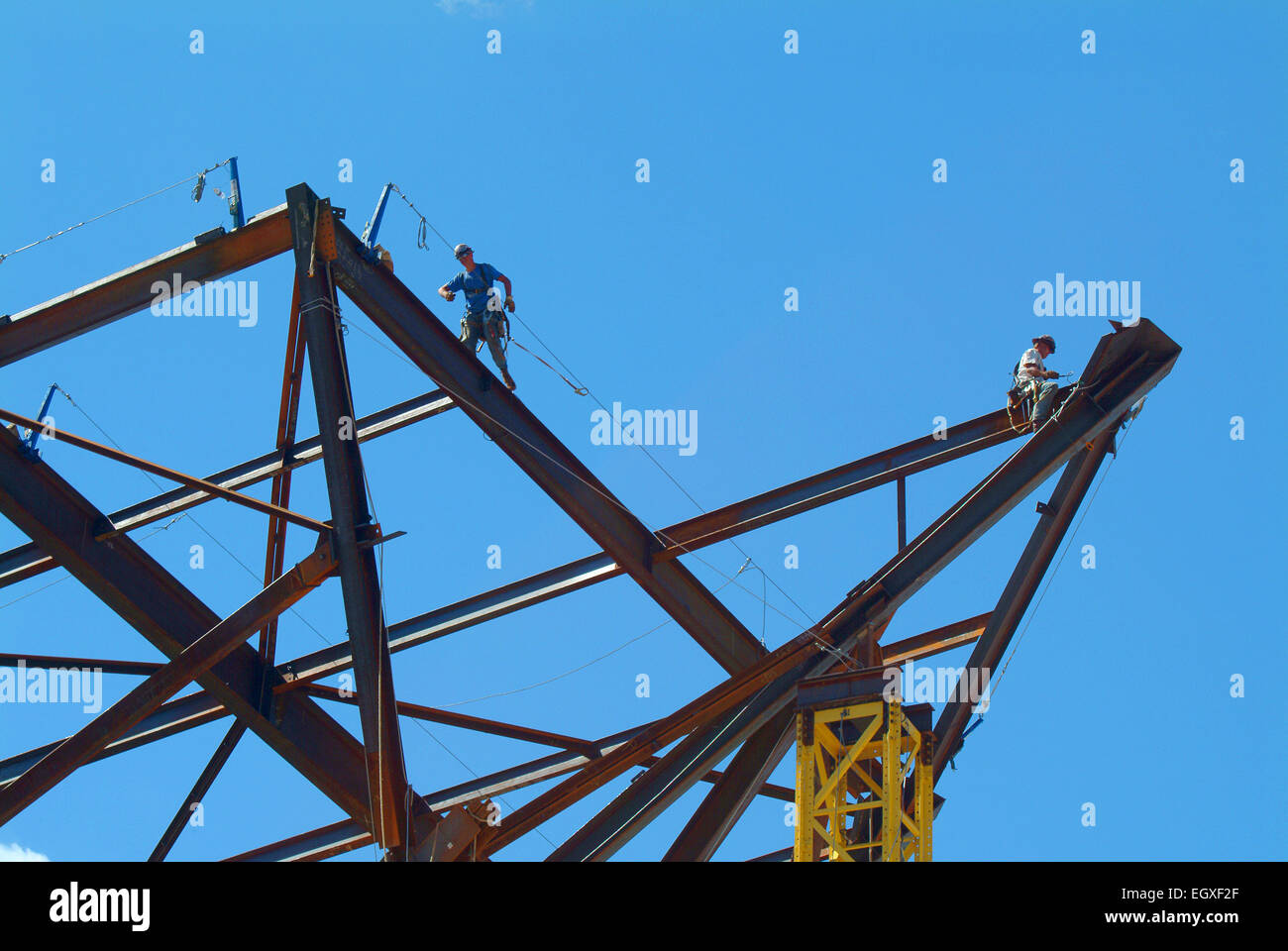 Construction workers at work on a structural steel building project ...