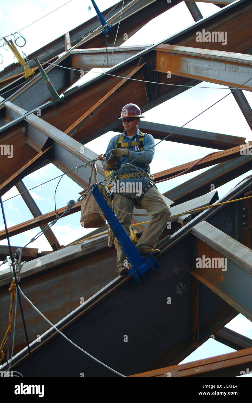 A construction worker takes a break on a structural steel building ...
