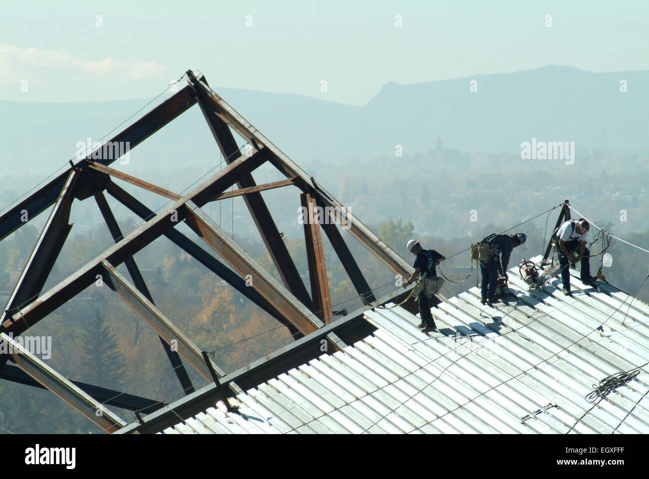 Construction workers install decking on a structural steel building ...