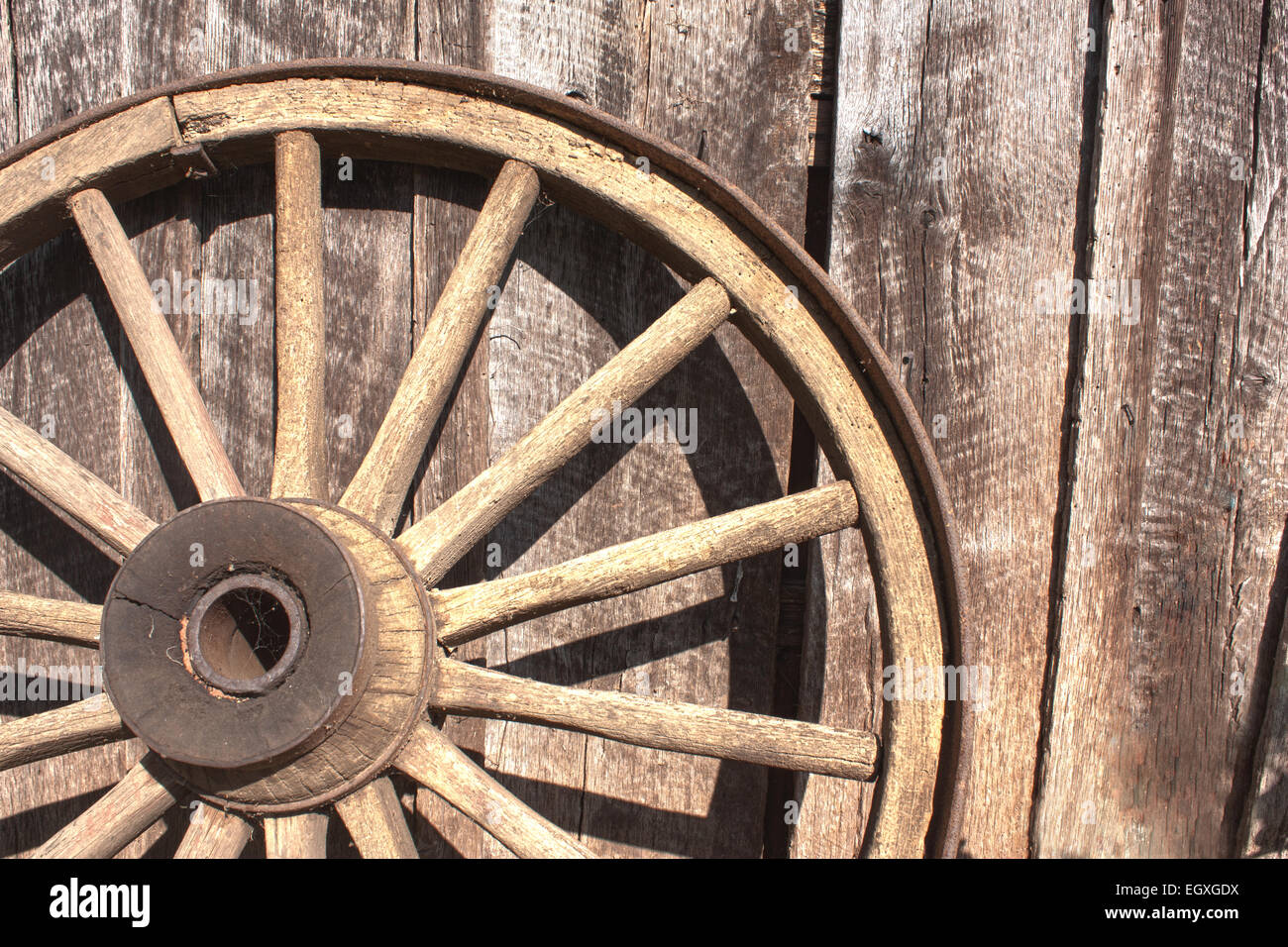 Wooden wagon wheel leaning against a weathered barn in Culpeper ...