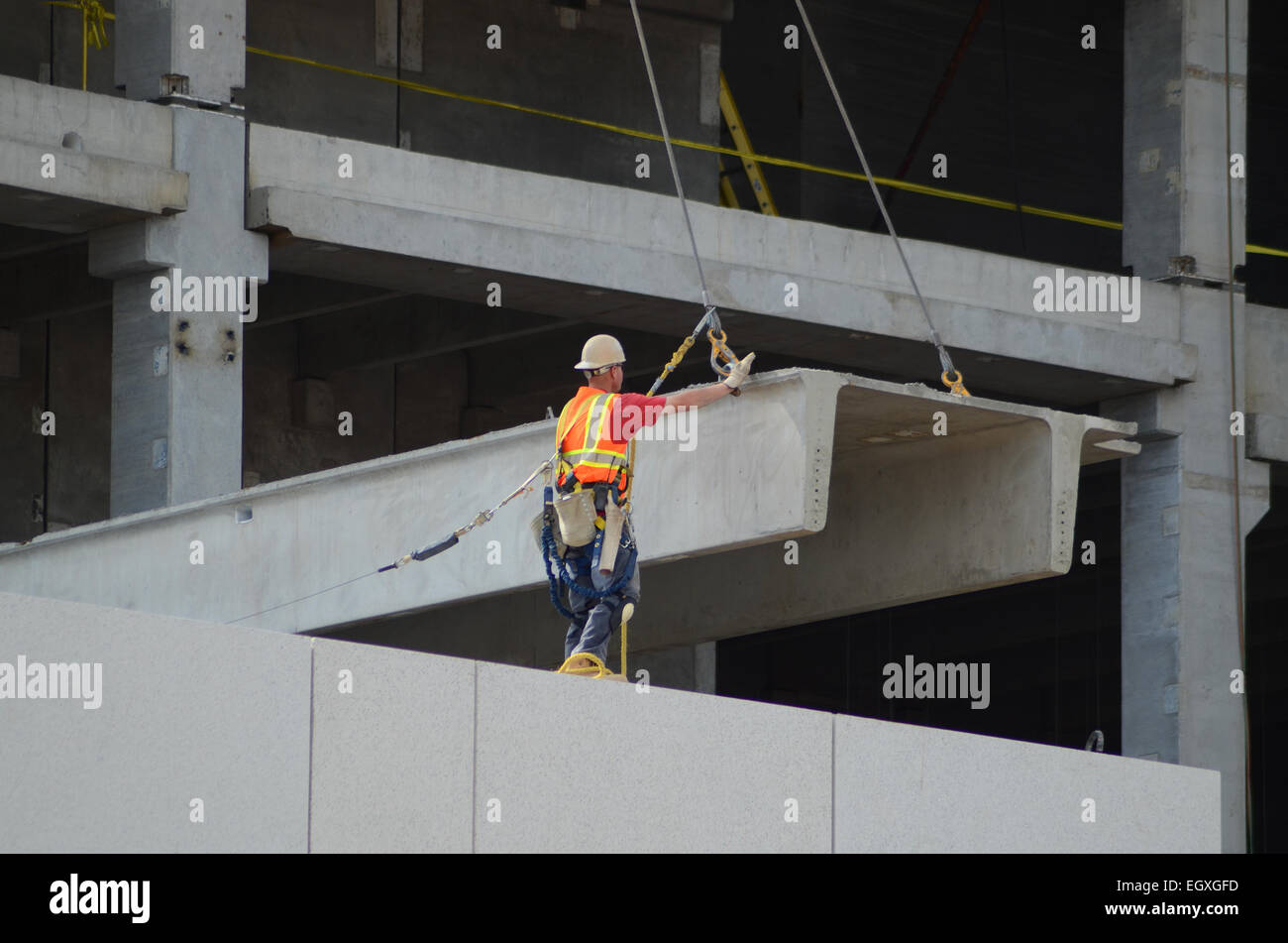 A construction worker guides a structural precast concrete double T ...