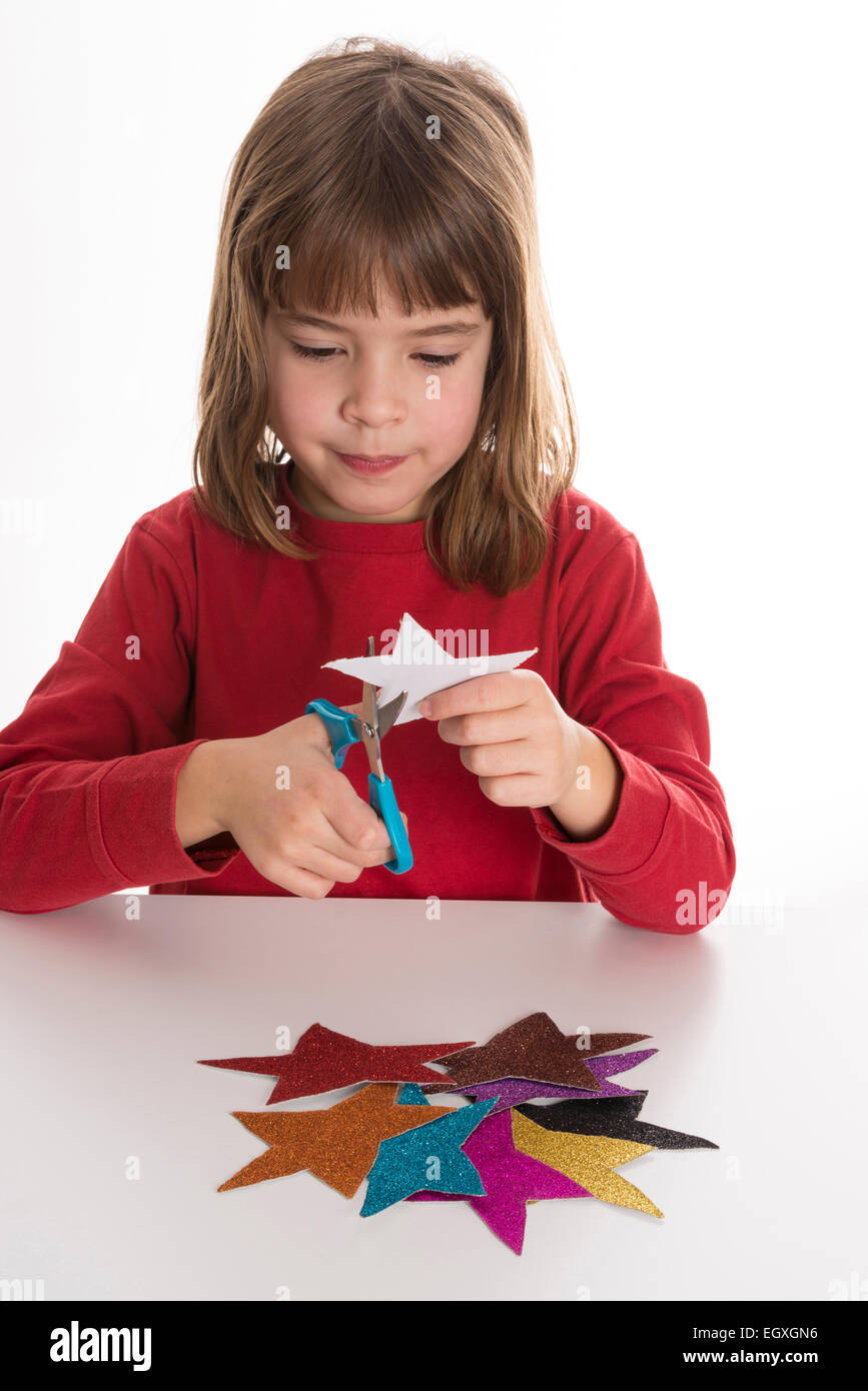 Little girl playing with stars made of paper with glitter colors Stock ...