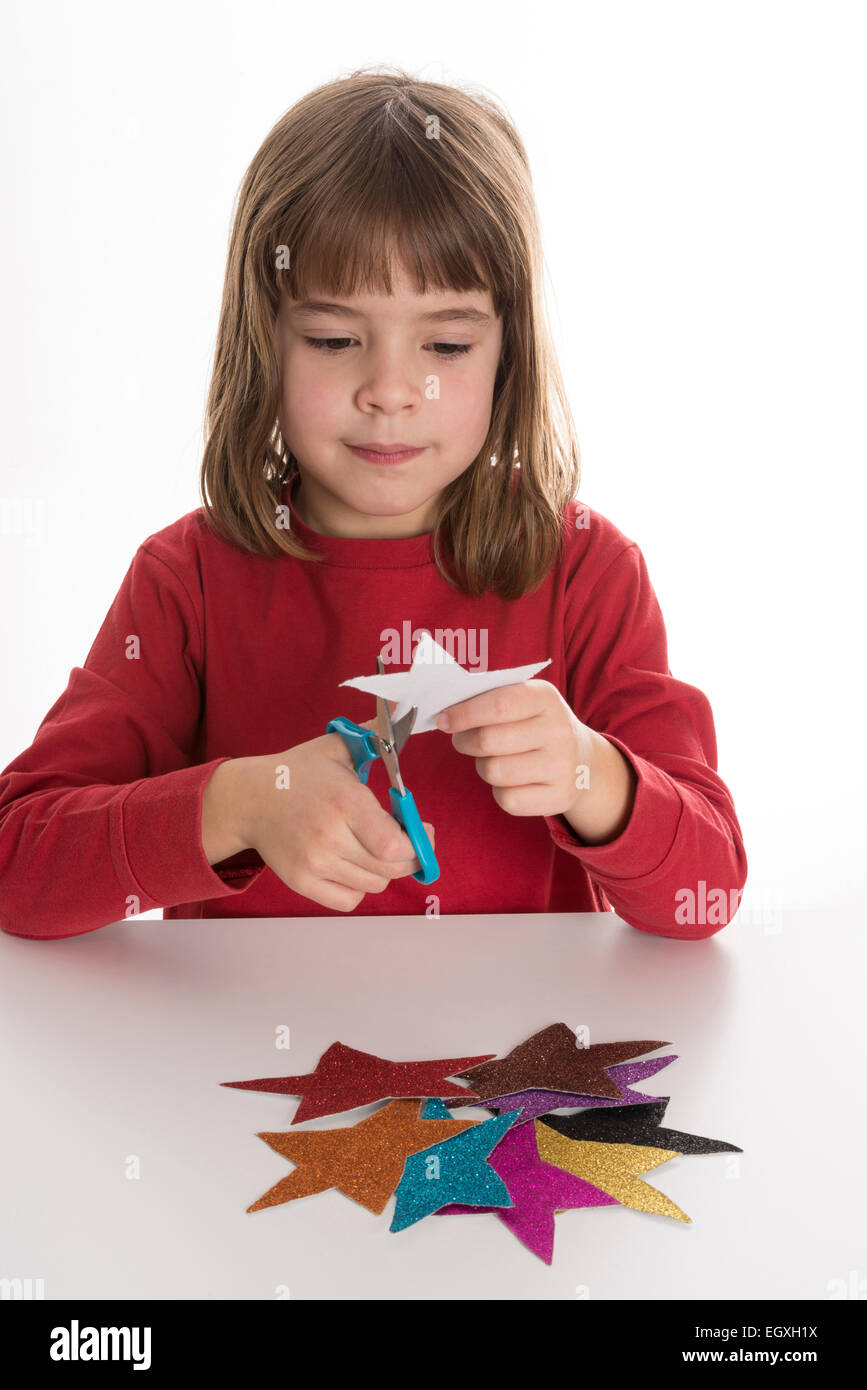 Little girl playing with stars made of paper with glitter colors Stock ...