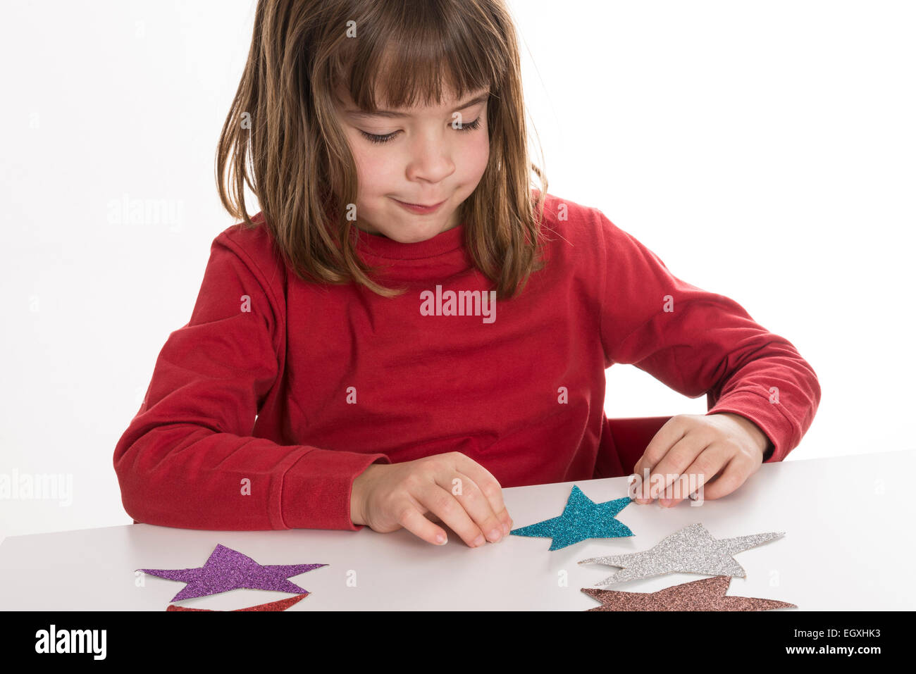 Little girl playing with stars made of paper with glitter colors Stock ...