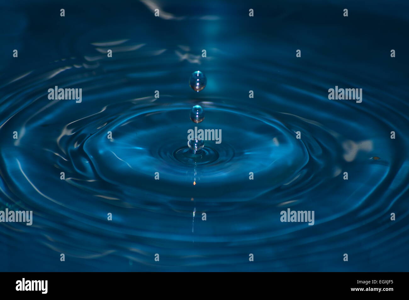 Water drop impact frozen mid splash with ripples and droplets Stock ...