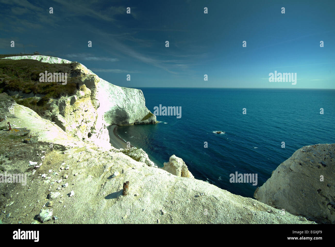 Steep bright white cliffs provide no access to a small beach and deep ...