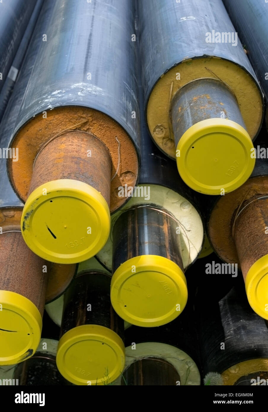 Construction tubes with yellow lids and rust Stock Photo - Alamy