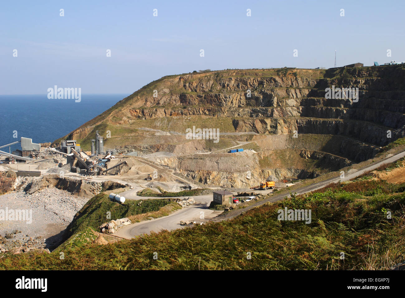 Ronez Quarry in summer sunshine on Jersey's north coast with clear blue ...