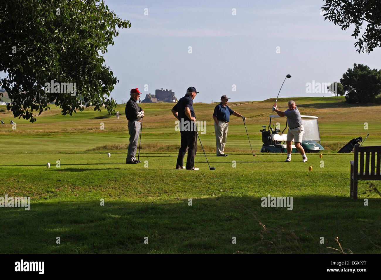 Golfers enjoying a round of golf in summer sunshine under cloudless ...