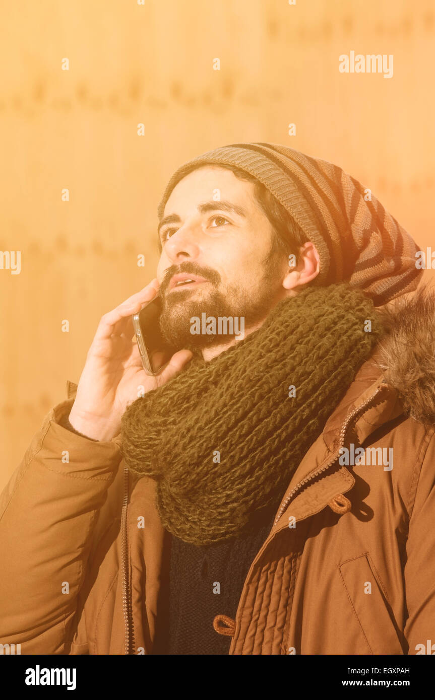 Lifestyle portrait of a young man using a smart phone outdoors ...