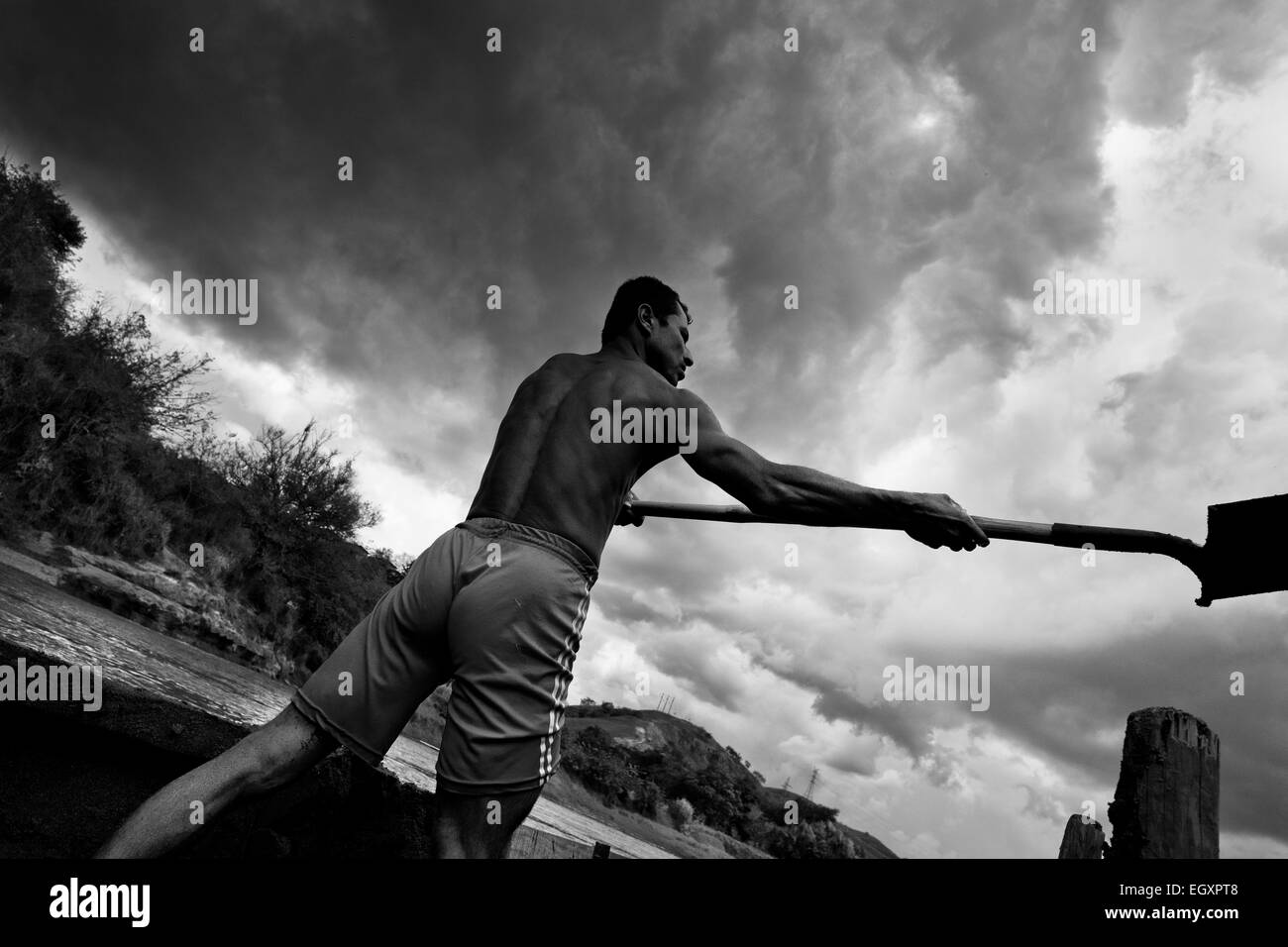 A Colombian sand miner unloads the extracted sand from his boat on the ...