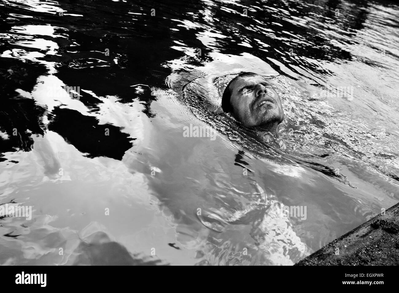 A Colombian sand miner dives under the water to extract sand from the ...