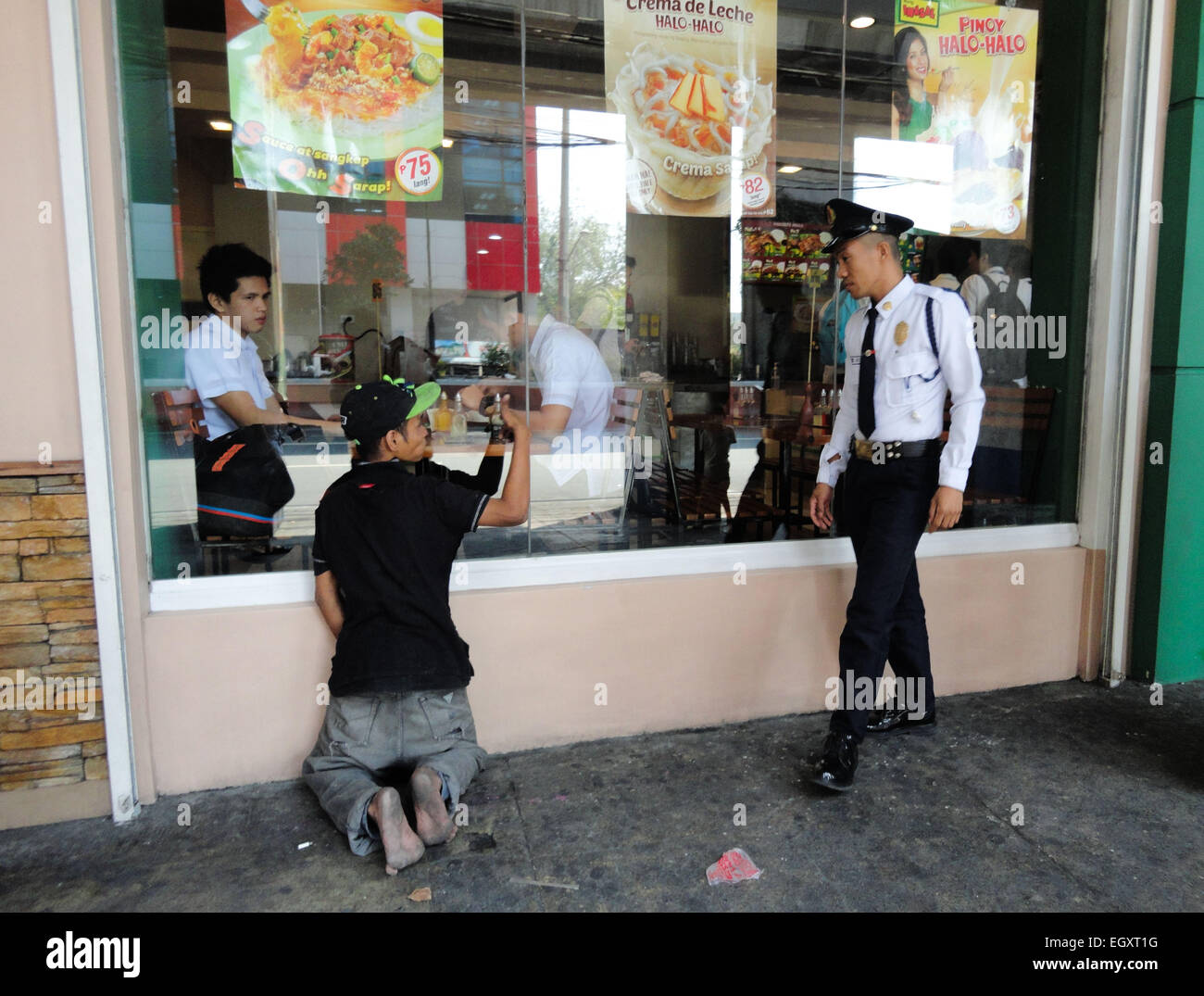 A security guard approaches a homeless man who was looking at students ...