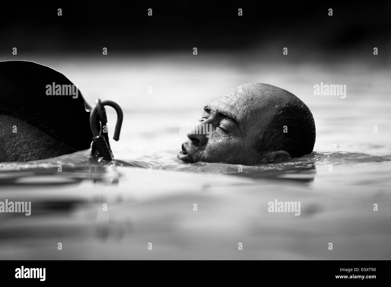 A Colombian sand miner dives under the water to extract sand from the ...