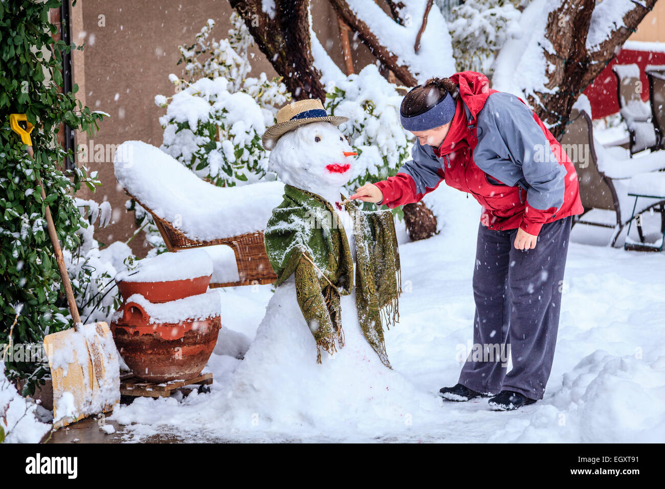 Woman is making a snowman in her front yard during snow storm Stock ...