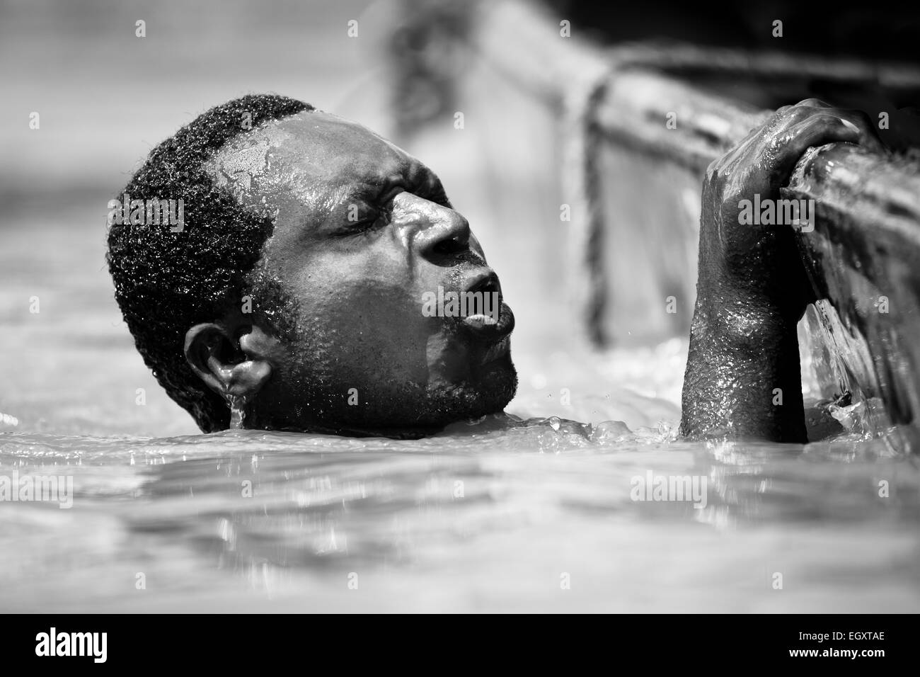 A Colombian sand miner dives under the water to extract sand from the ...