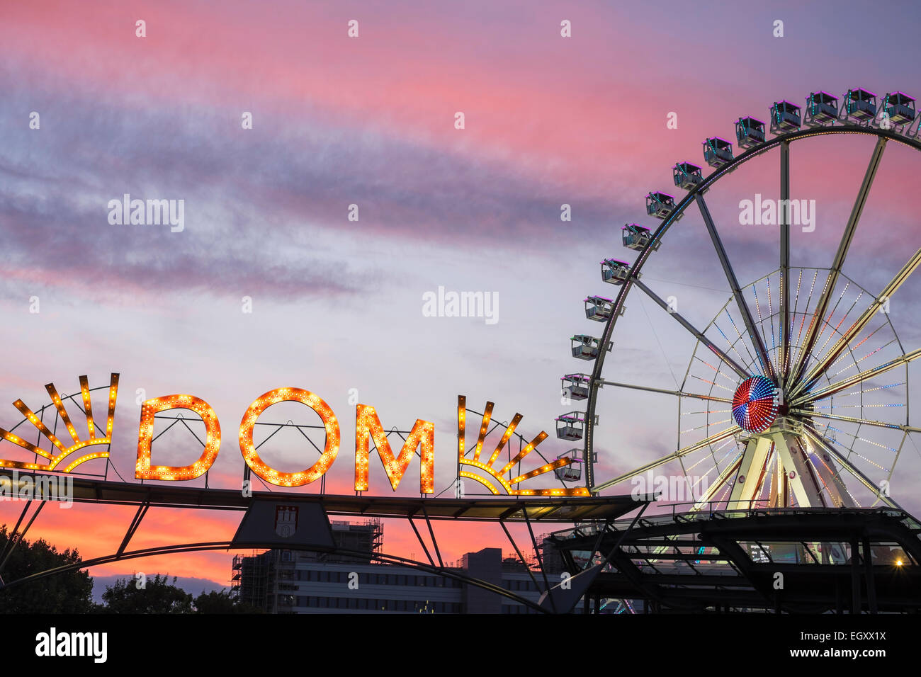 Illuminated entrance to Hamburger DOM funfair and ferris wheel at ...