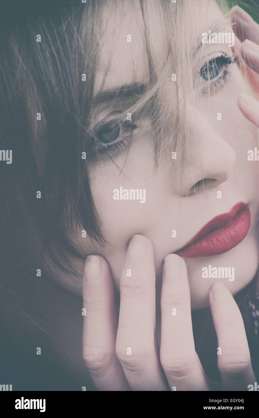 Beautiful young woman hands touching face looking away Stock Photo - Alamy