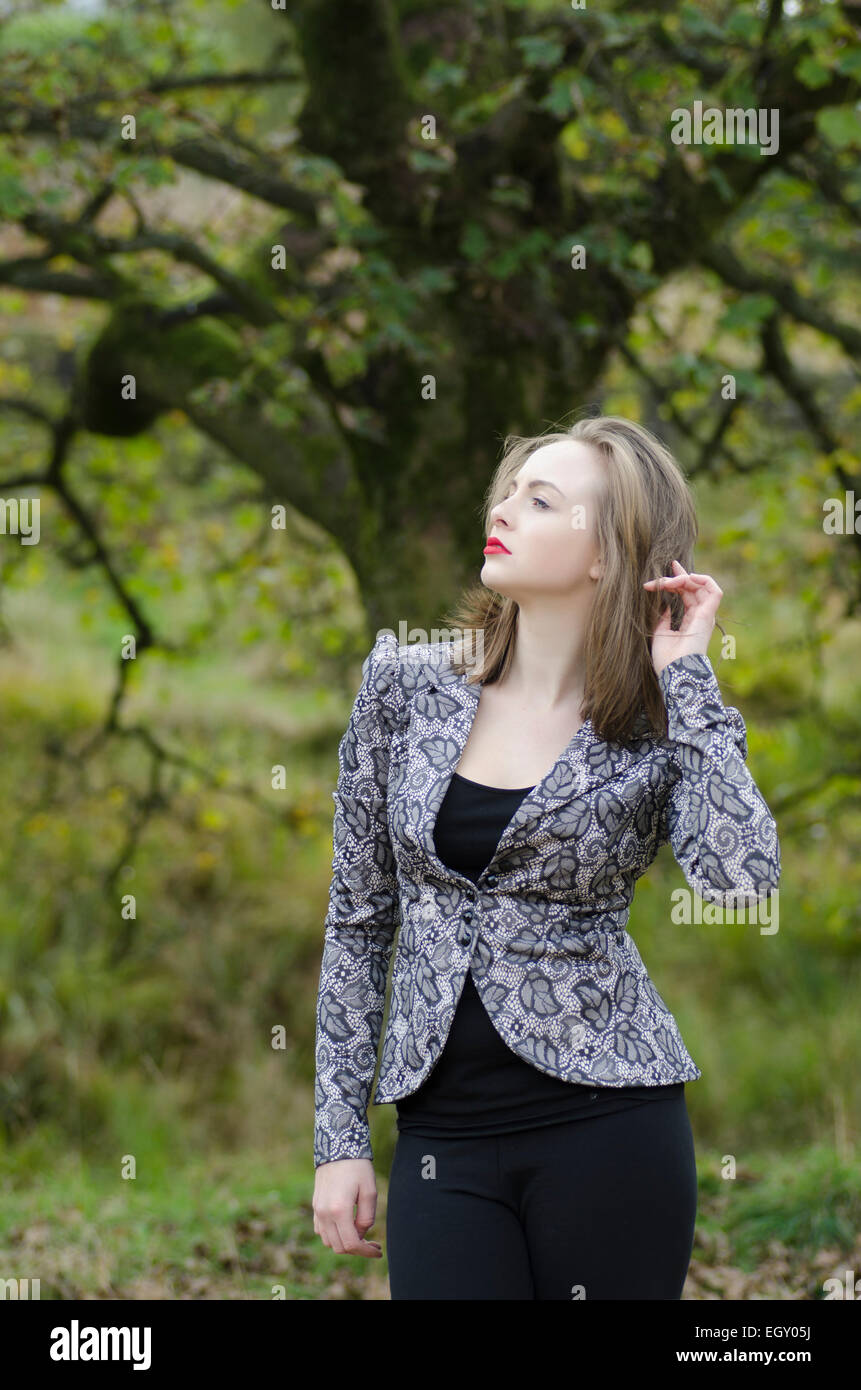 Beautiful young woman standing in the countryside looking away Stock ...