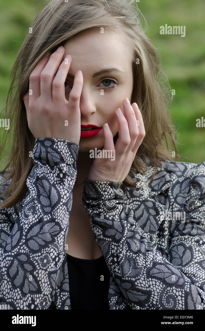 Beautiful young woman hiding face with hands Stock Photo - Alamy