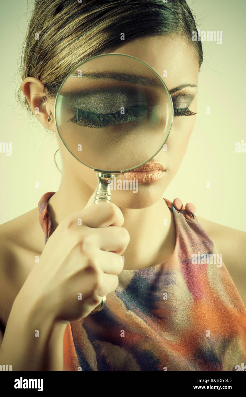 Beautiful young woman with a magnifying glass Stock Photo - Alamy