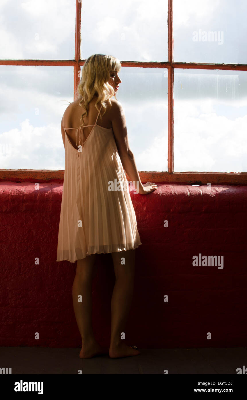 Woman standing by the window Stock Photo - Alamy