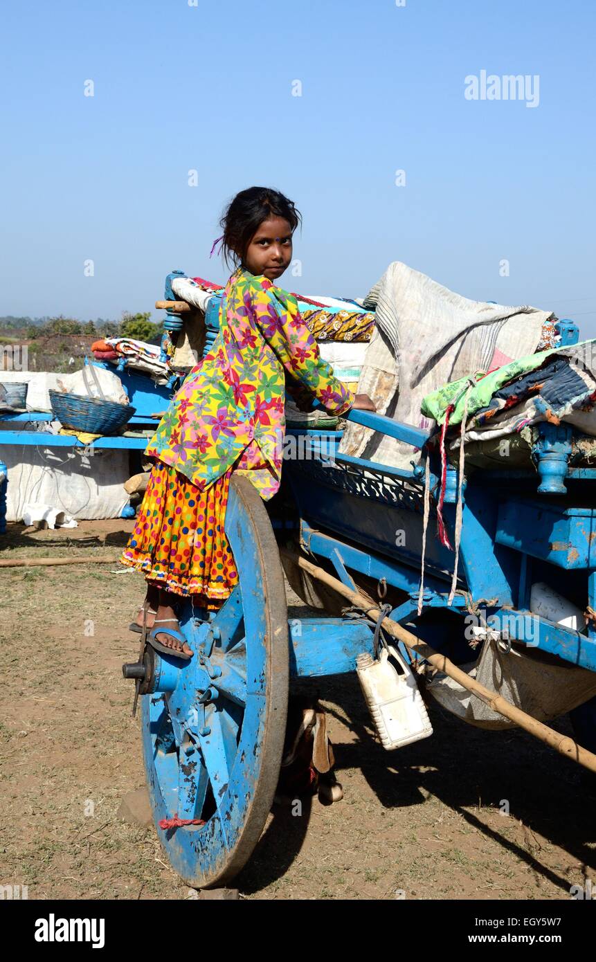 Young Indian Rajasthani gypsy girl standing on the wheel of a ...