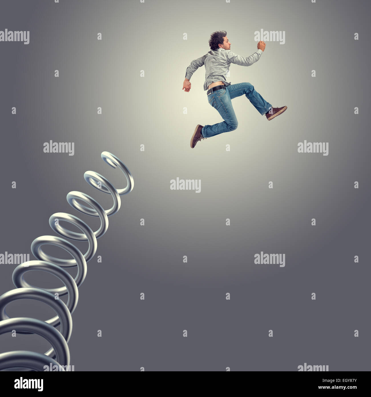 jumping man and huge metal springer Stock Photo - Alamy