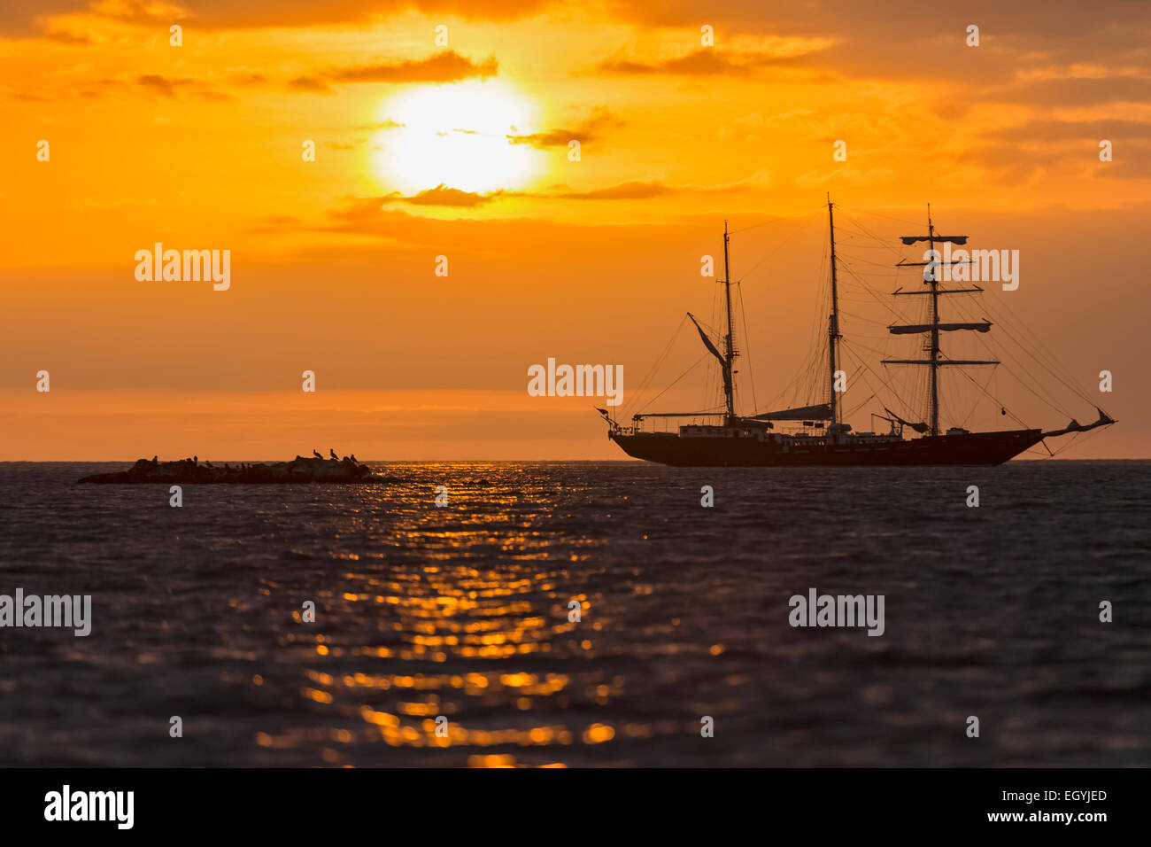 Pacific Ocean, sailing ship at Galapagos Islands at sunset Stock Photo ...
