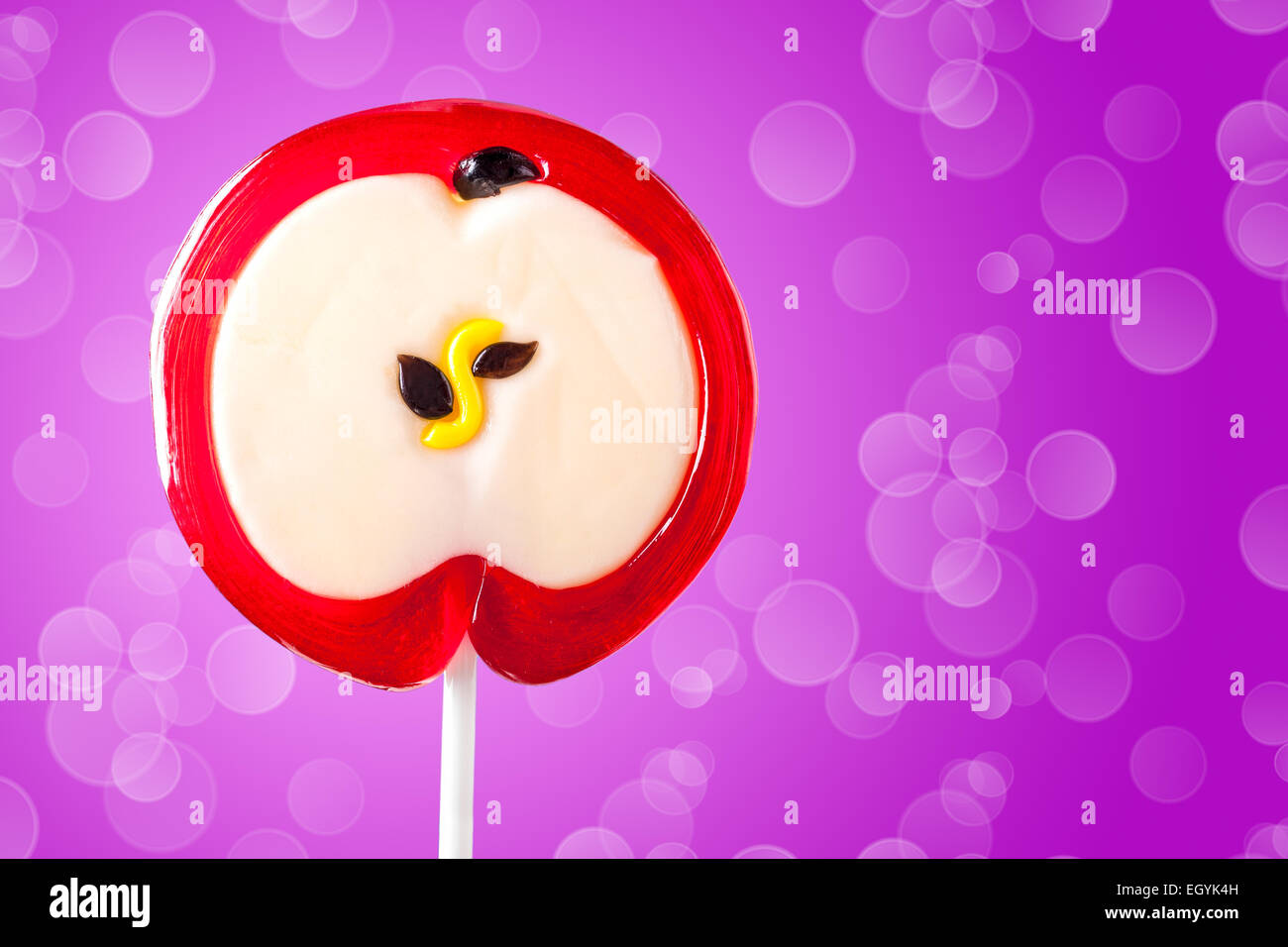 lollipop in the form of an apple on a purple background Stock Photo - Alamy