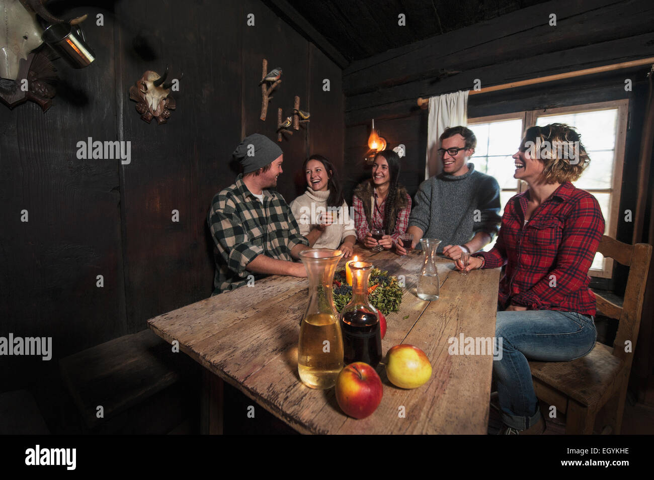 Group of young people drinking in mountain hut Stock Photo - Alamy