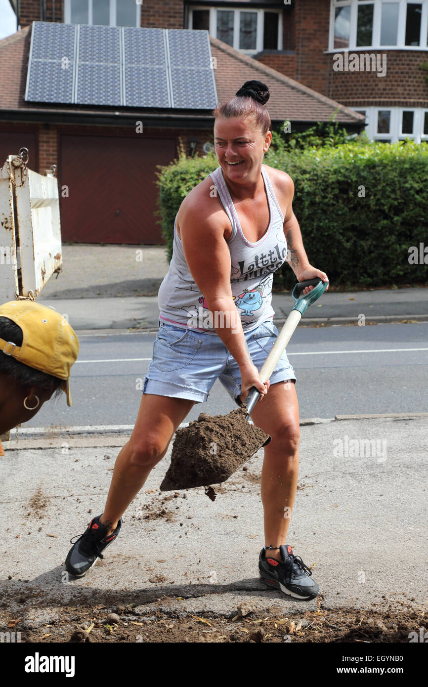 Women shovelling soil into lorry Stock Photo - Alamy