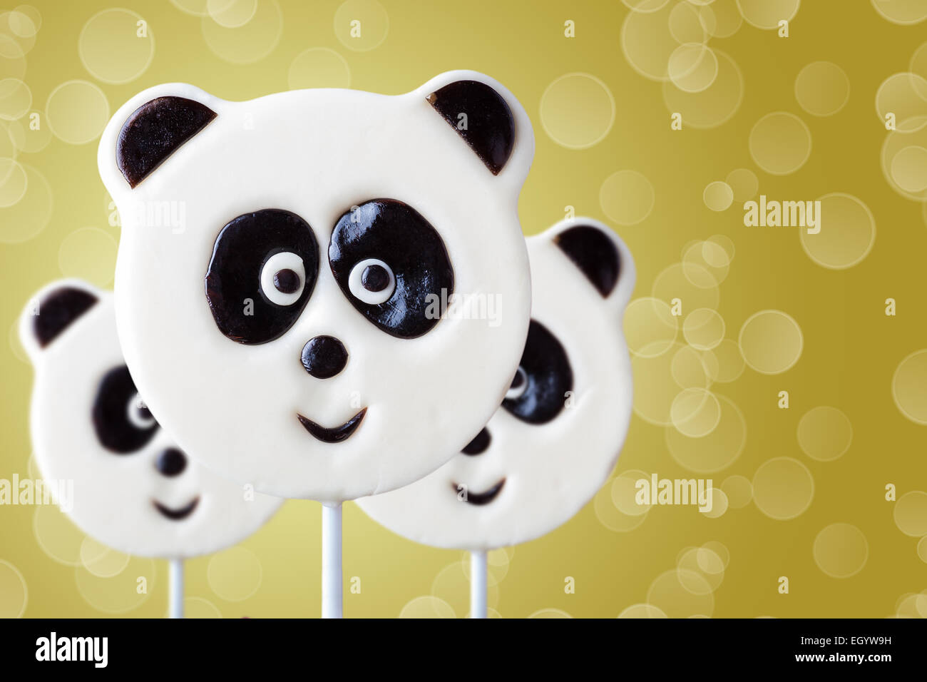 lollipop in the form of an panda on a yellow background Stock Photo - Alamy