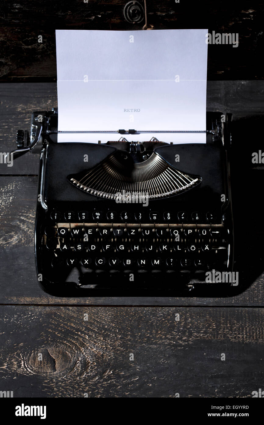 Old black typewriter on dark wood Stock Photo - Alamy