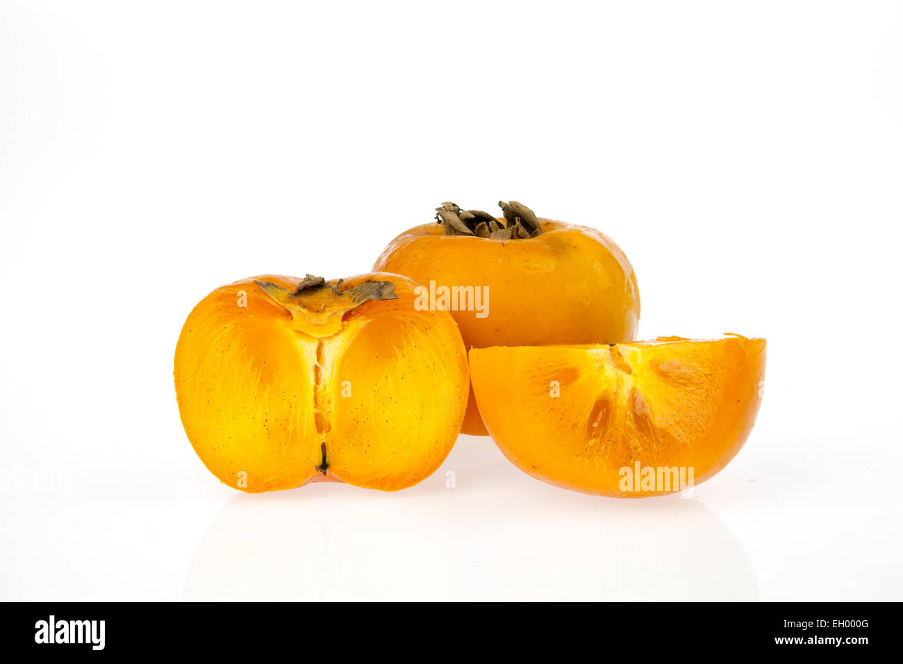 Persimmons, one whole and one cut in two pieces isolated on a white ...