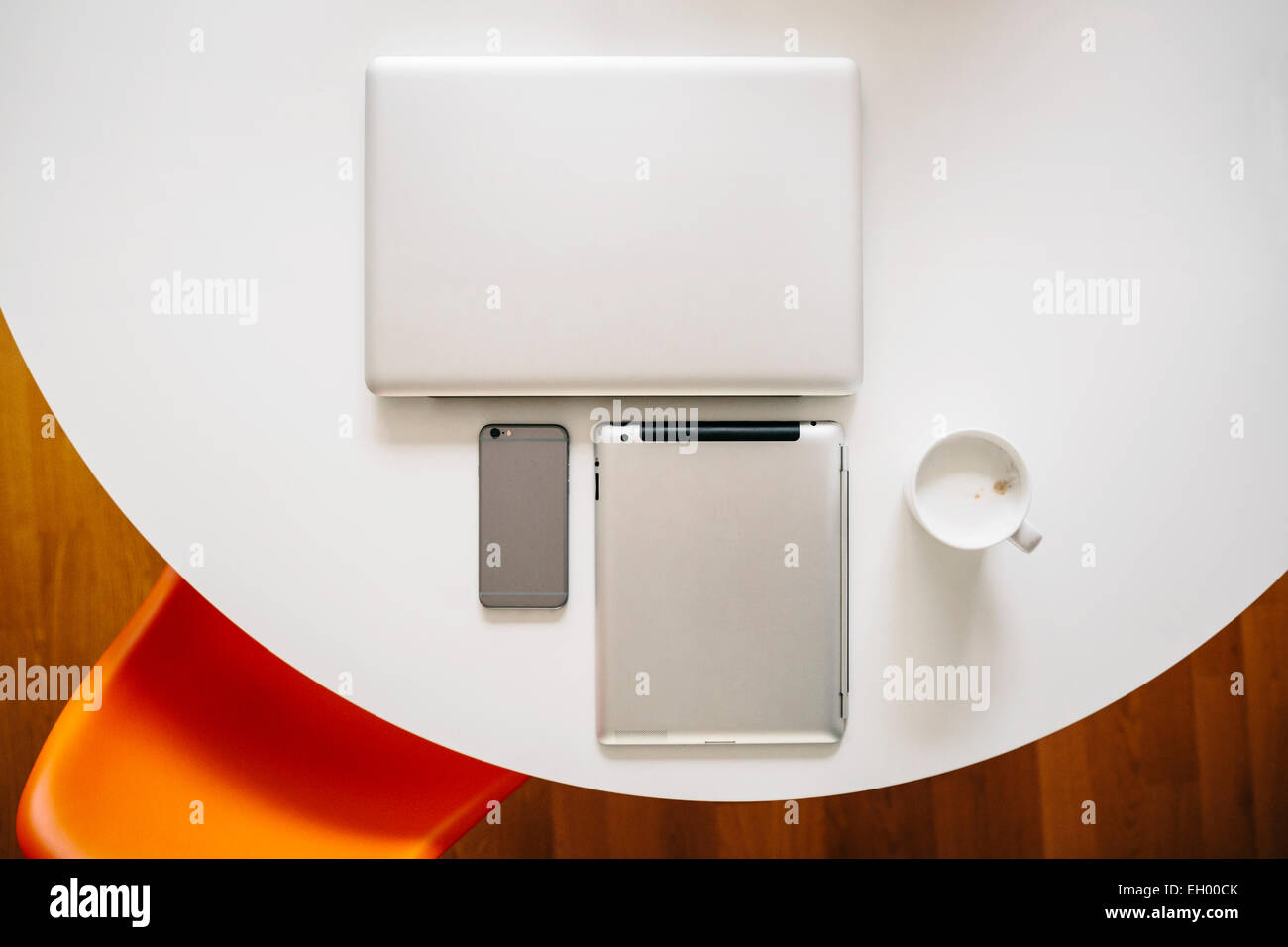 Three mobile devices and coffee on a white round table Stock Photo - Alamy