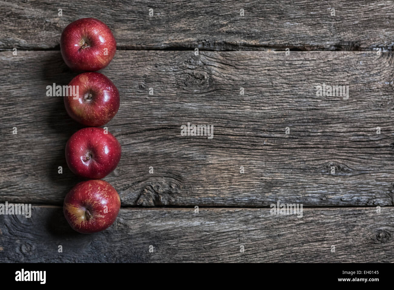 Four red apples on dark wood Stock Photo - Alamy
