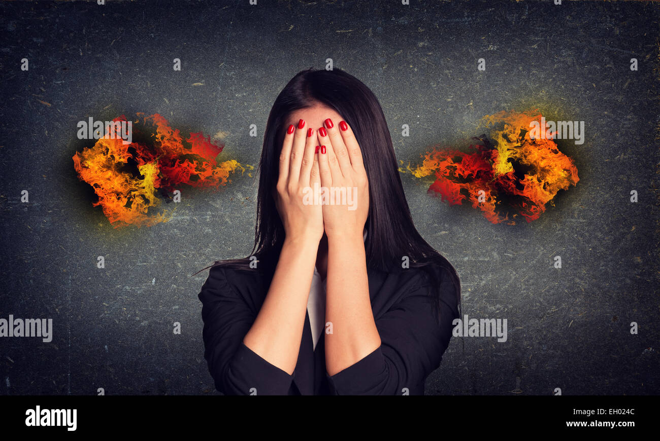 Crying woman with fire from ears. Concrete gray wall as backdrop Stock ...