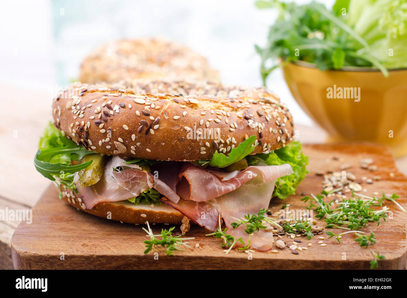 Wholemeal bagels with ham, gherkin, lollo rosso, rocket and cress Stock ...