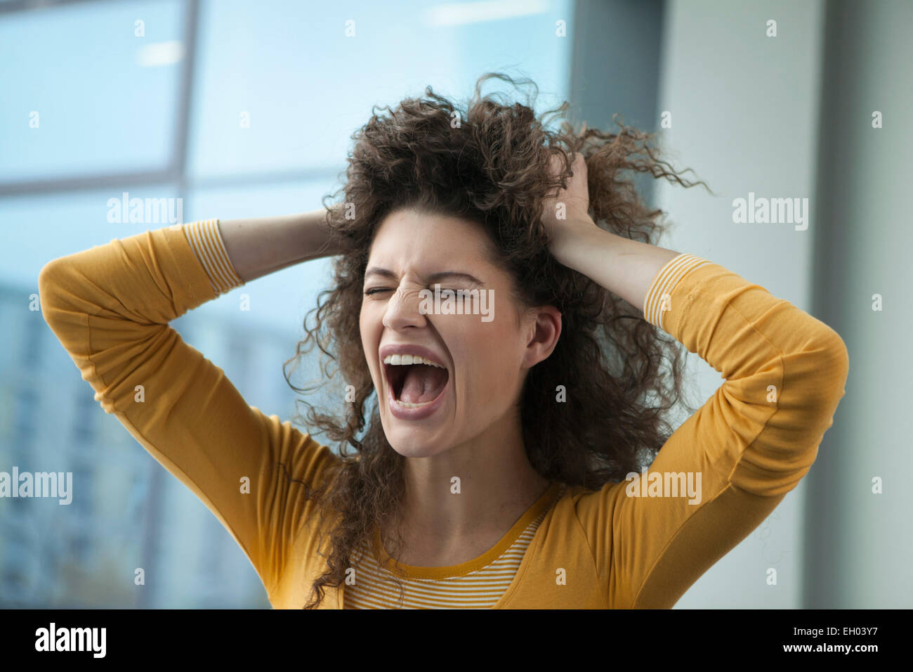 Screaming young woman with hands in hair Stock Photo - Alamy
