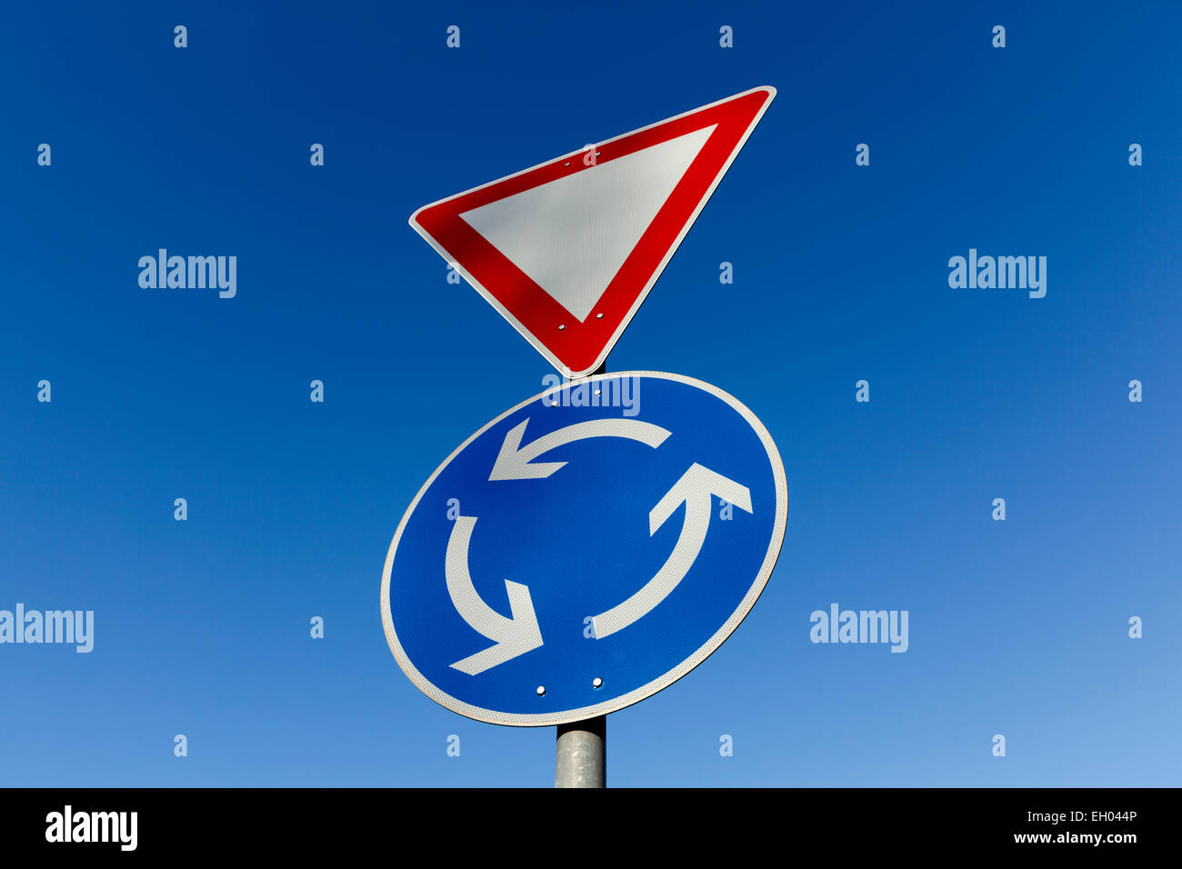 Germany, give way and roundabout sign in front of blue sky Stock Photo ...