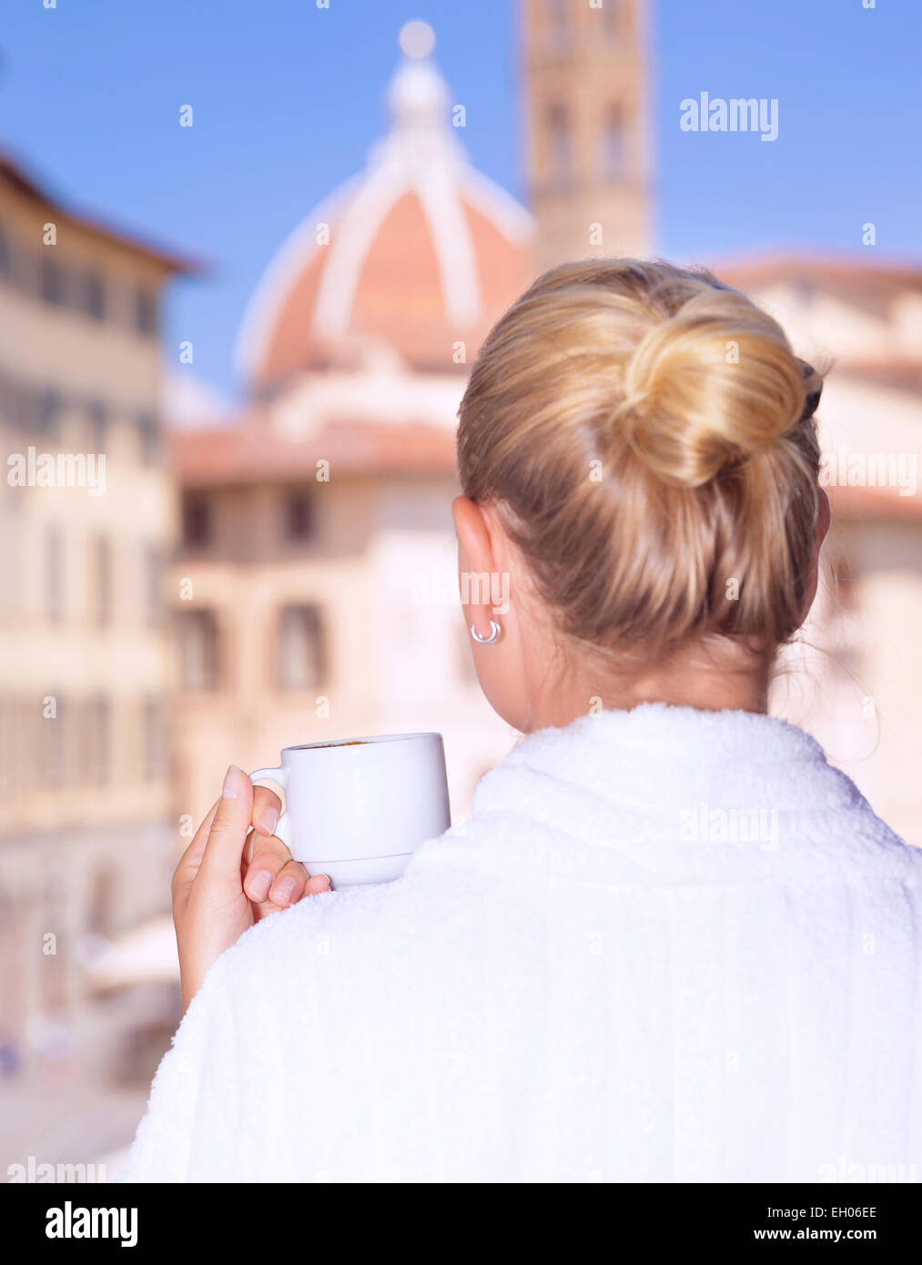 Back side on woman having morning coffee in the hotel, wearing white ...
