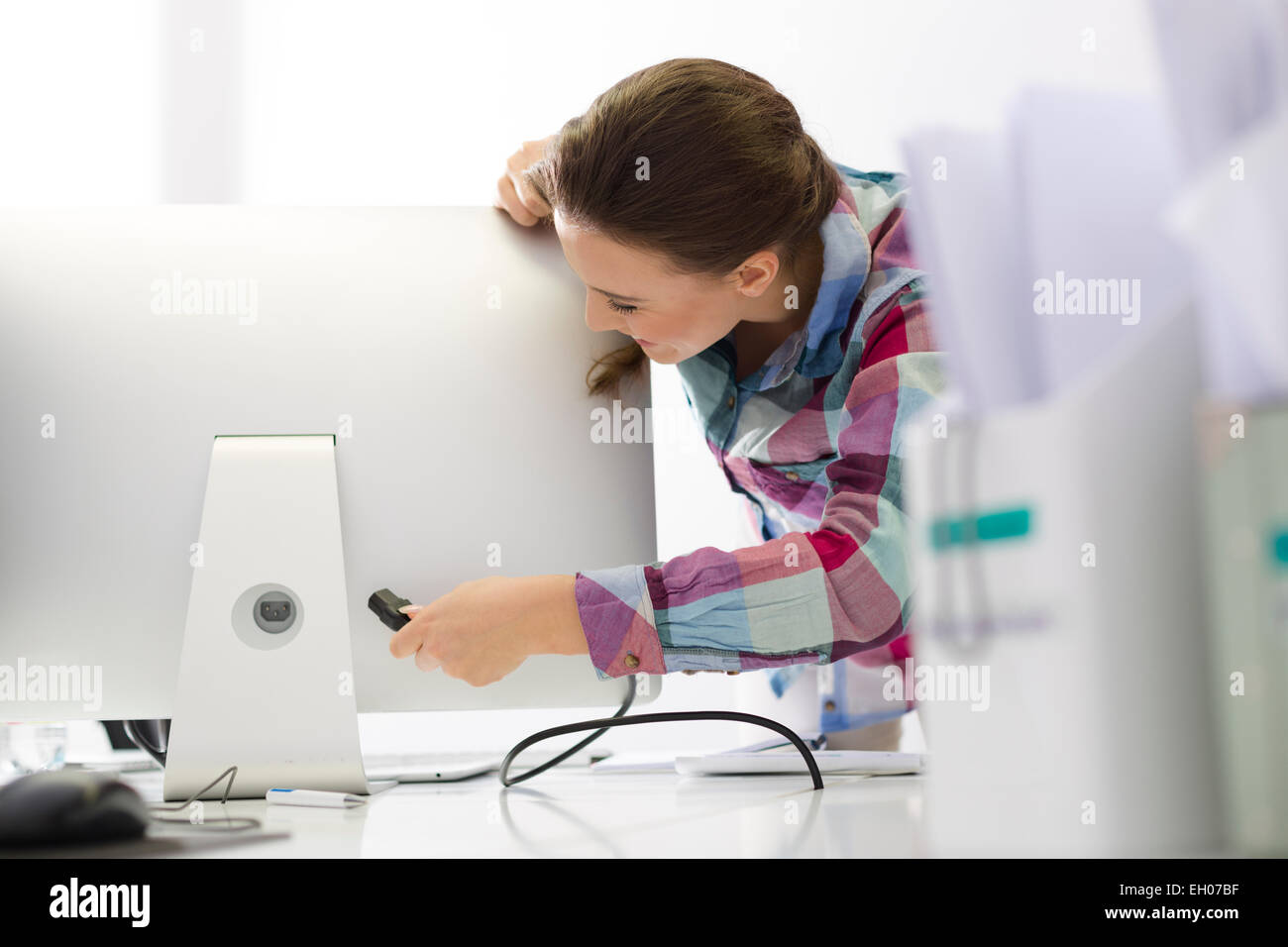 Young woman in office connecting computer screen Stock Photo - Alamy