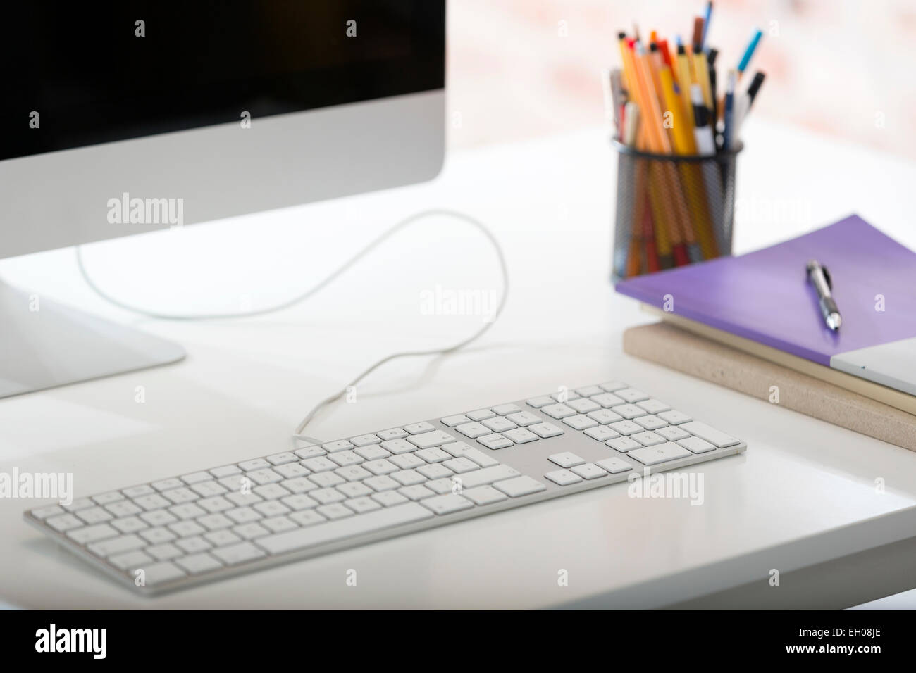 Computer, pencils and folders on desk in office Stock Photo - Alamy